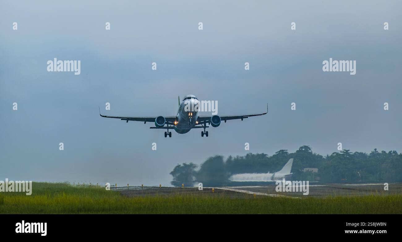 A commercial airplane taking off from the runway. The plane is angled ...