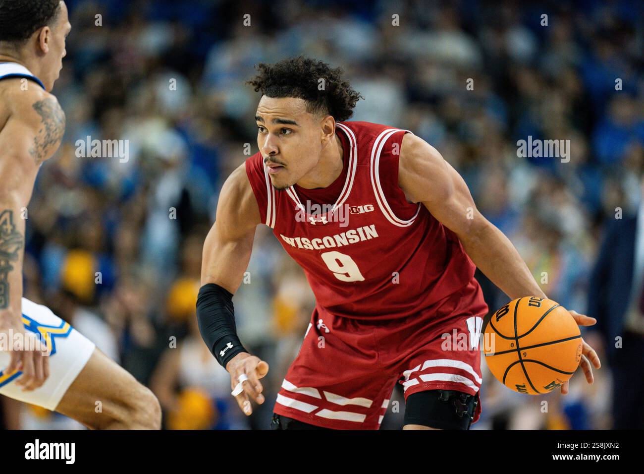 Wisconsin Badgers guard John Tonje (9) is guarded by UCLA Bruins guard ...