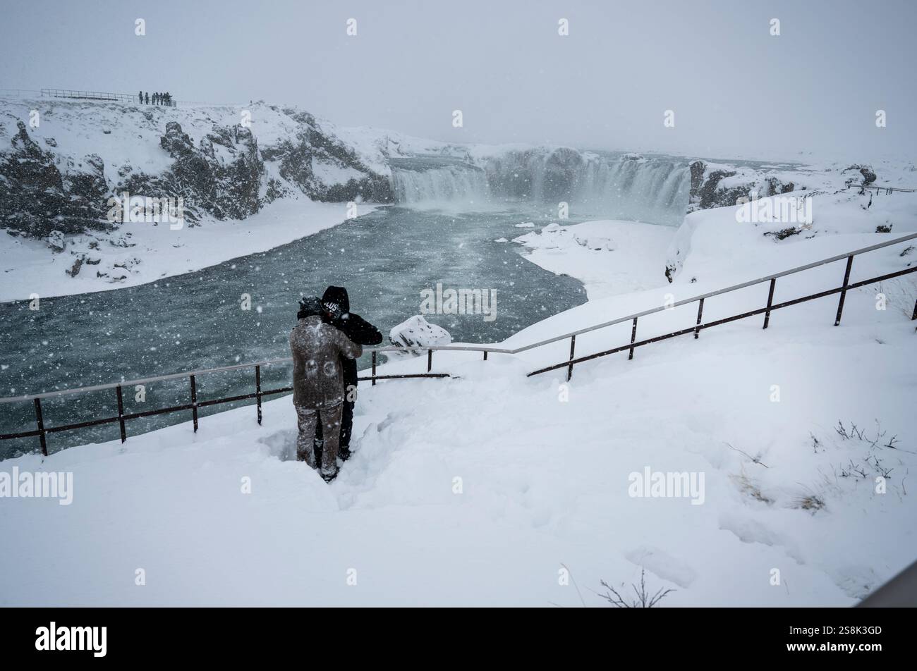 Two people are seen standing close to a park facility next to the ...