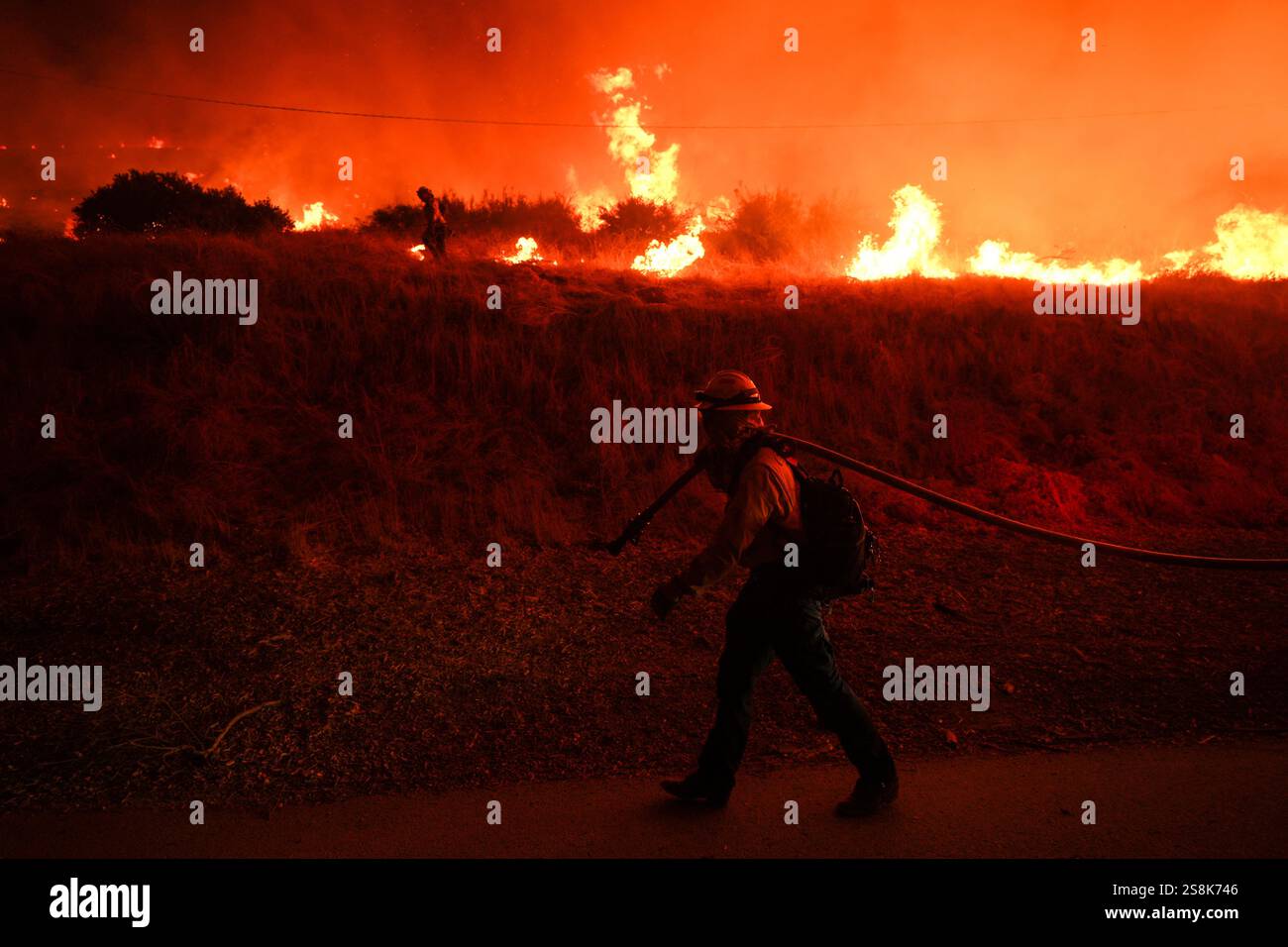 A firefighter monitors flames caused by the Hughes Fire along Castaic ...