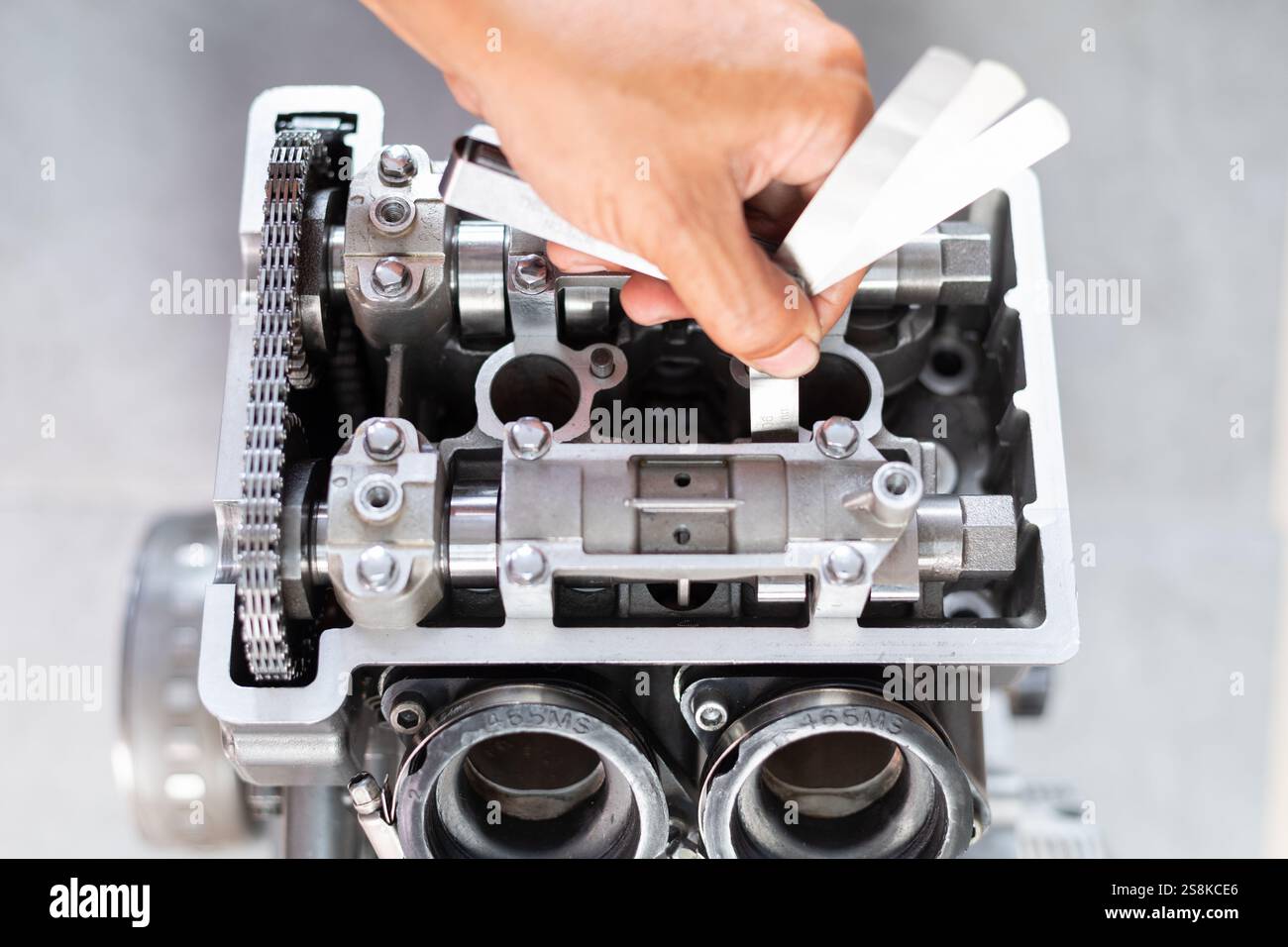 Setting valve clearance using a feeler gauge to measure clearance to ...