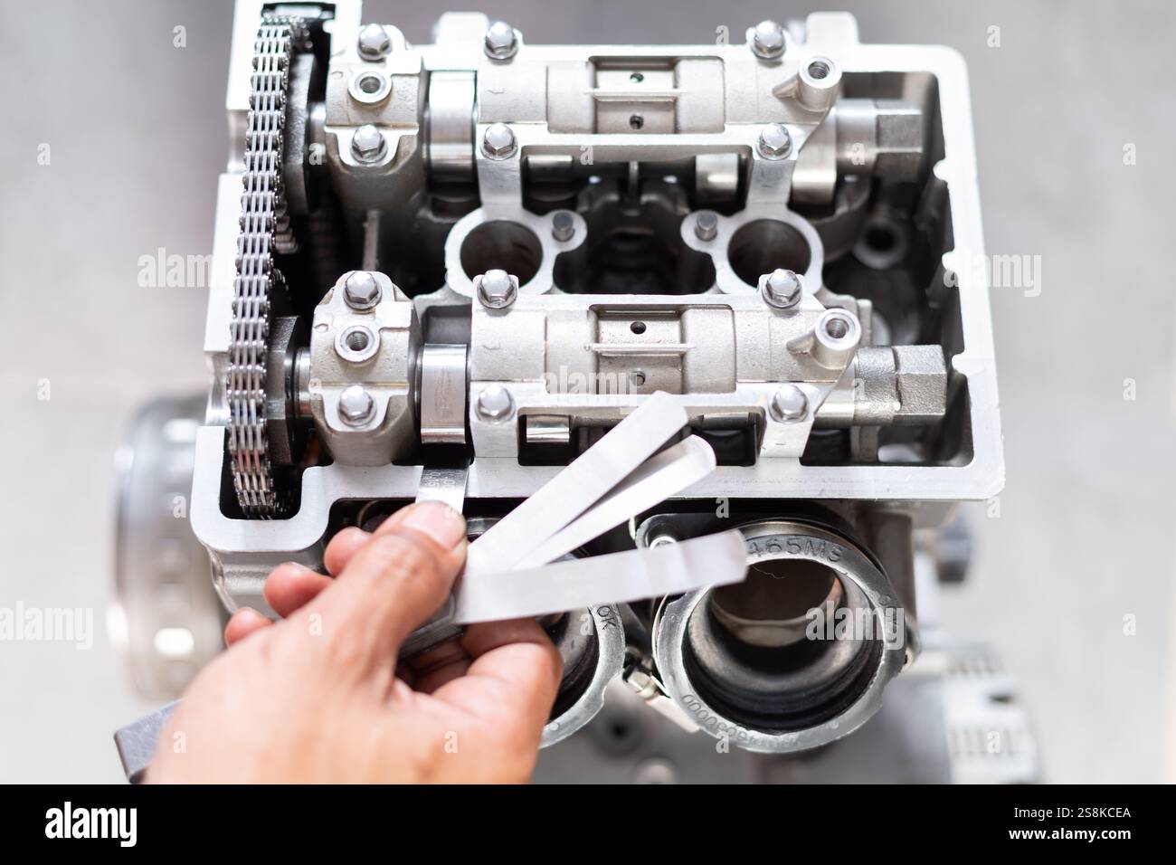 Setting valve clearance using a feeler gauge to measure clearance to ...