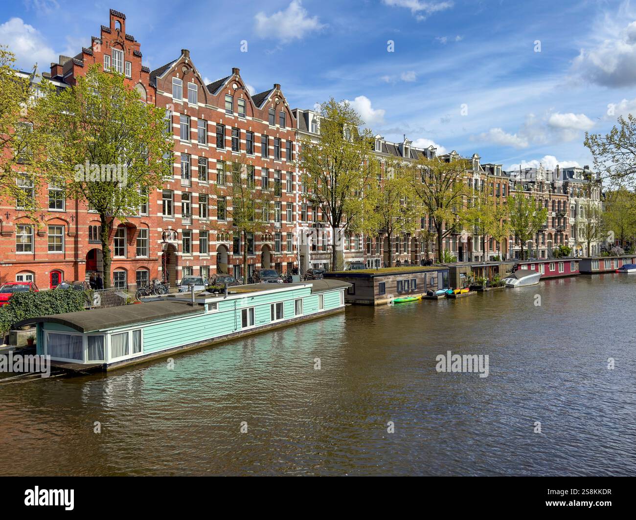 Houses and houseboats along Singelgracht canal, Amsterdam, Netherlands ...