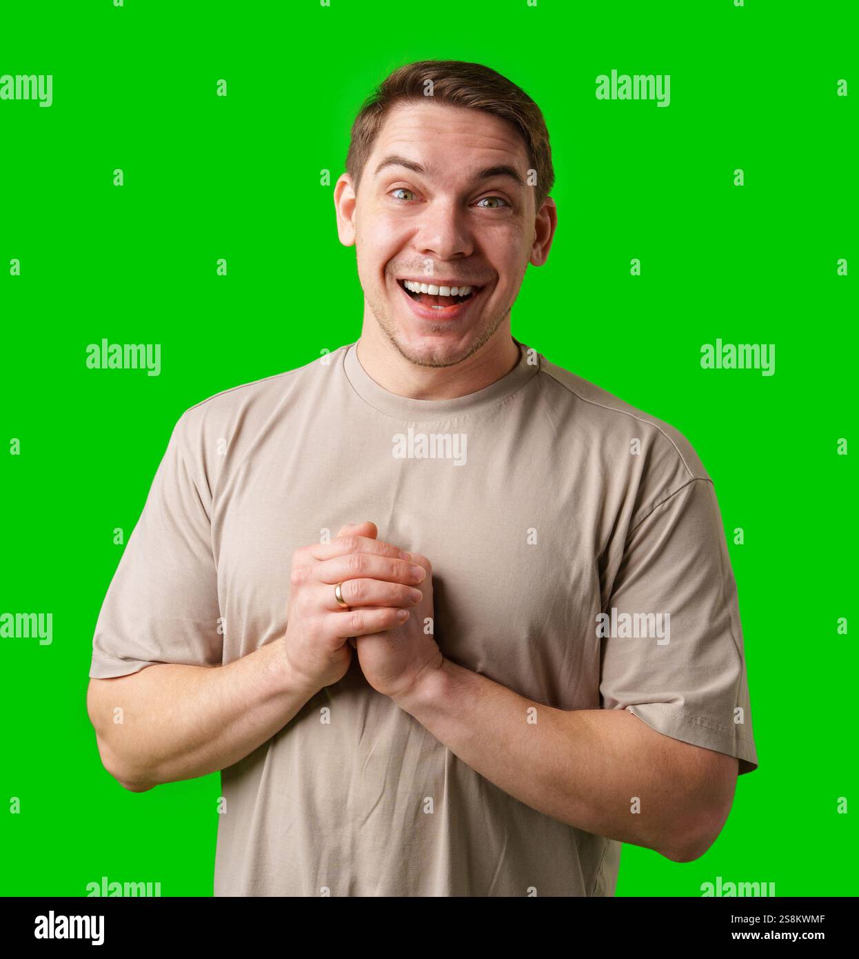 A cheerful man with a friendly smile poses against a bright green ...