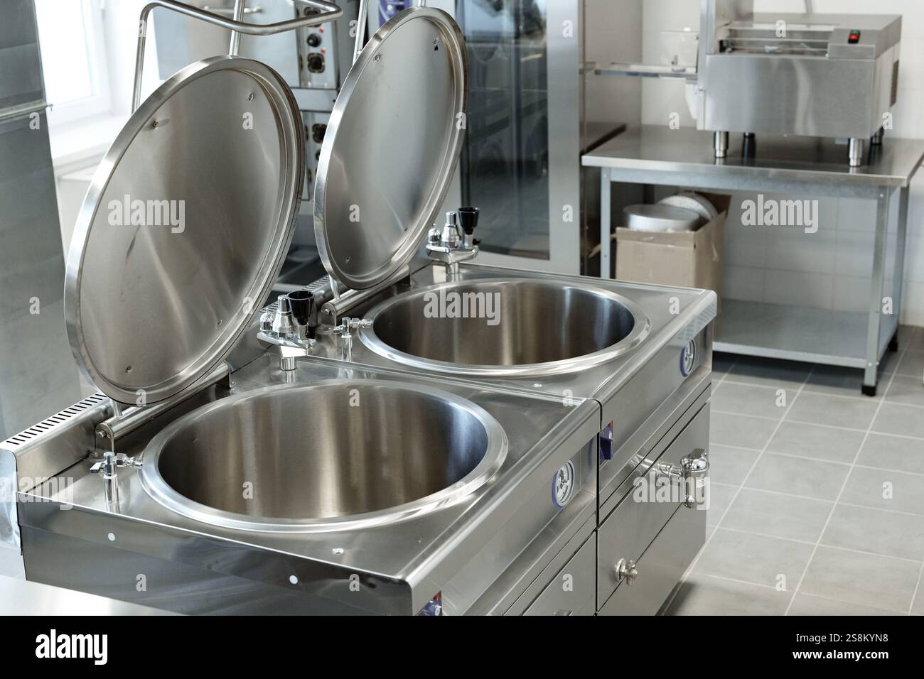 Stainless steel cooking equipment in a modern commercial kitchen with ...