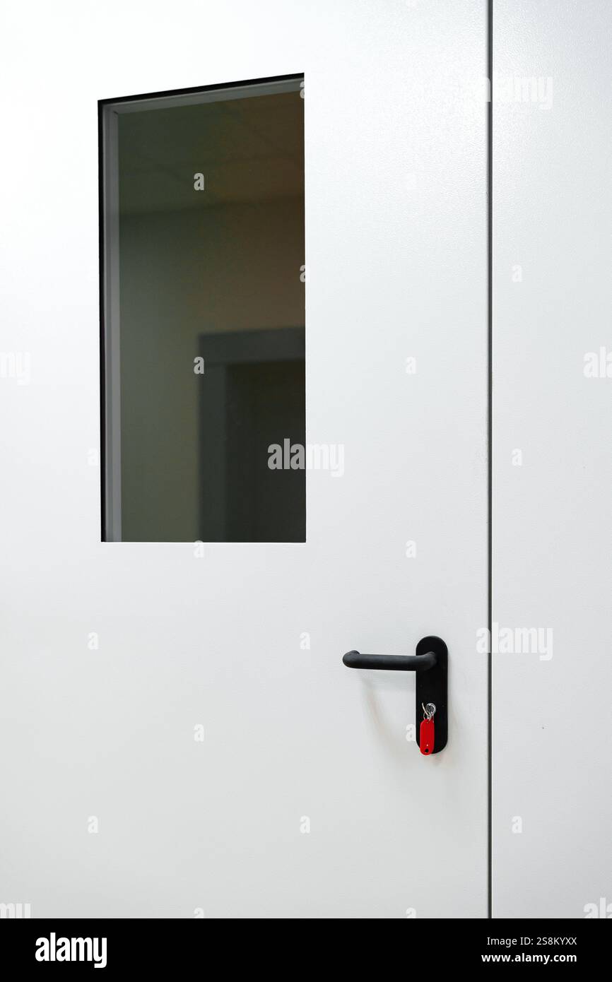 Simple white door with window and secure handle in a modern interior ...