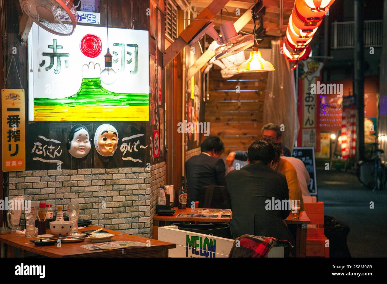 A food street restaurant in the Akabane district of Tokyo. Japan at night with people seated ...