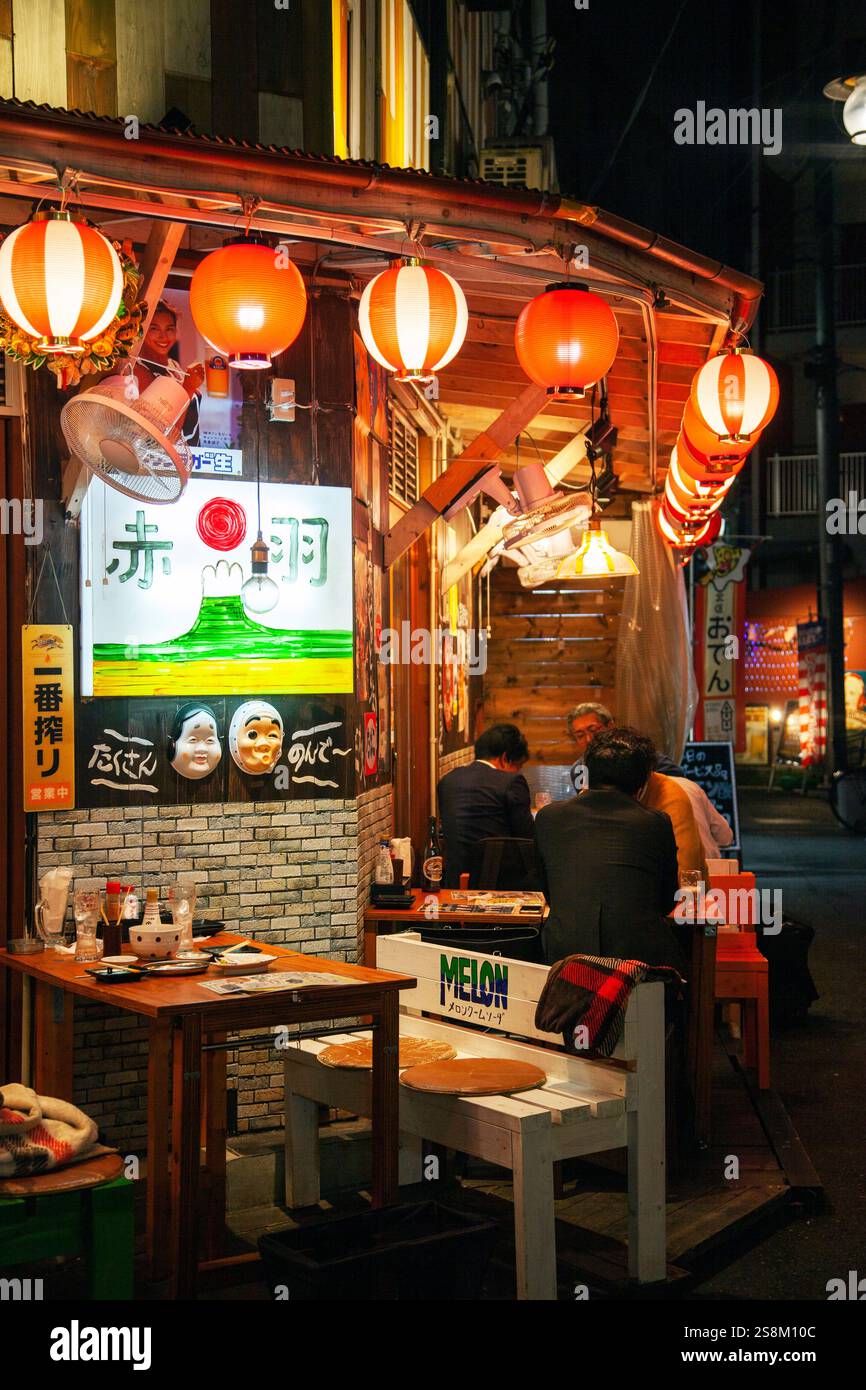 A food street restaurant in the Akabane district of Tokyo. Japan at night with people seated ...