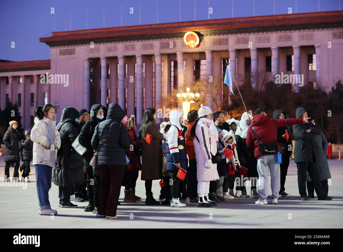 Tourists watch the flag raising ceremony at Tiananmen Square in Beijing ...