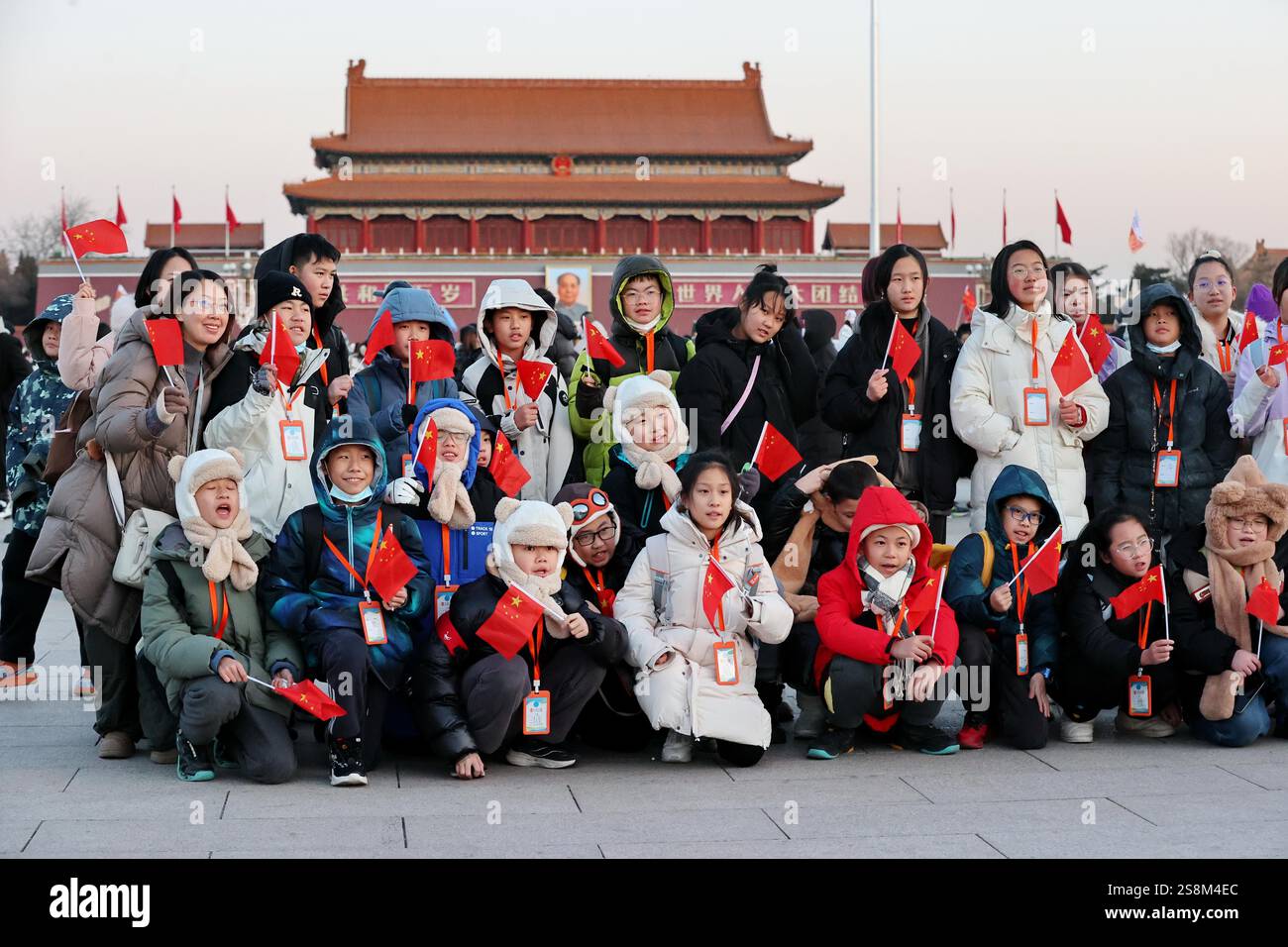 Tourists watch the flag raising ceremony at Tiananmen Square in Beijing ...