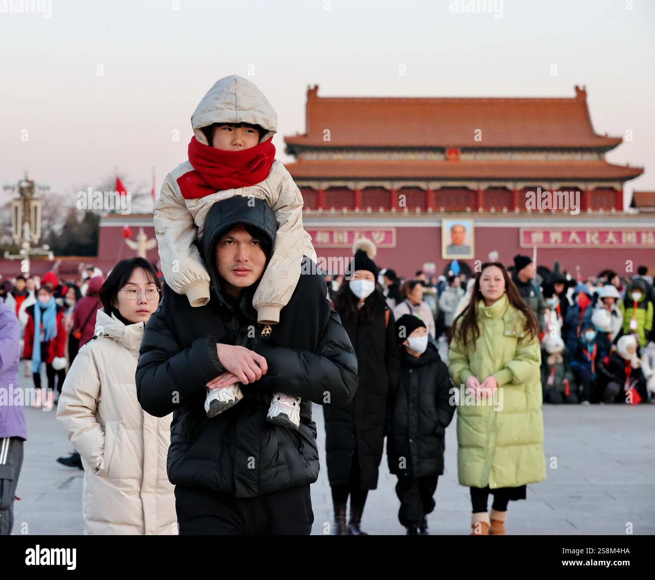 Tourists watch the flag raising ceremony at Tiananmen Square in Beijing ...