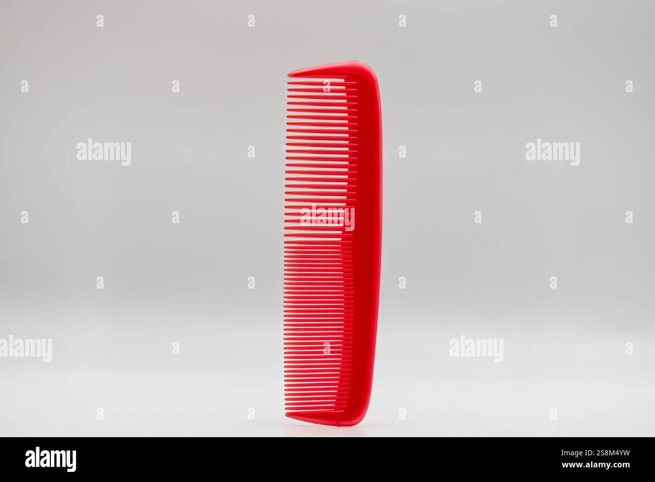Colorful red comb arranged on a white background Stock Photo - Alamy