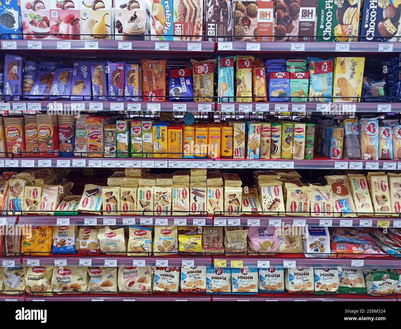 Variety of packaged snacks and cookies displayed on supermarket shelves ...