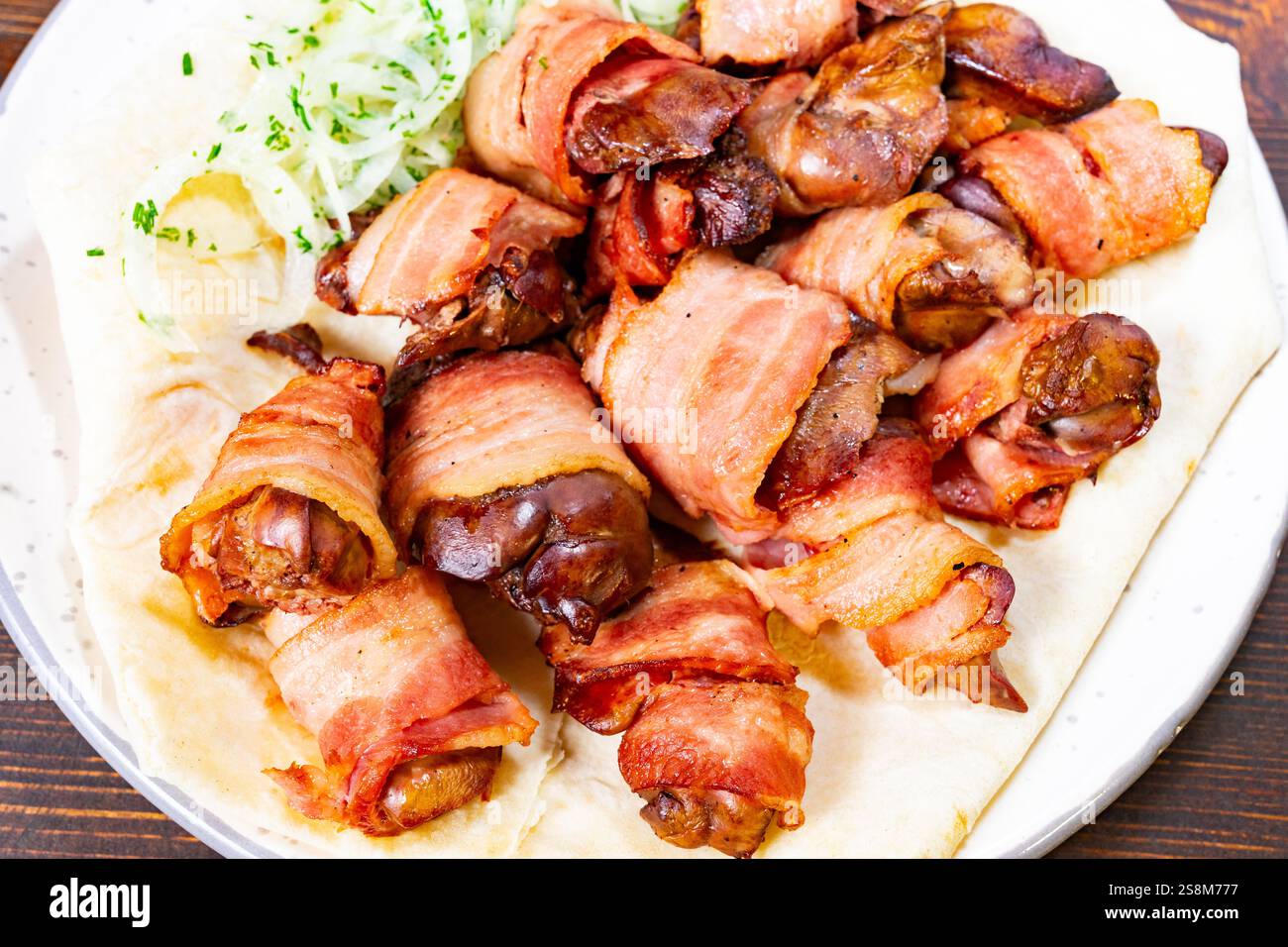 A delicious plate features bacon-wrapped meat, golden and crispy ...