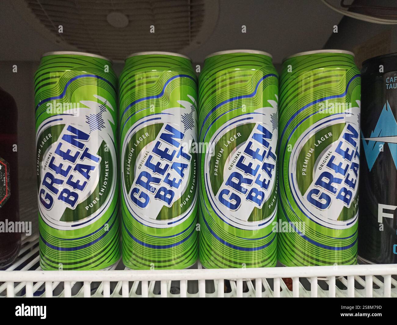 Green beat premium lager cans in fridge display Stock Photo - Alamy