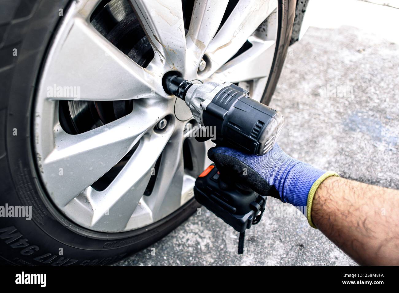 Auto mechanic using impact wrench cordless to change car wheel , Car ...
