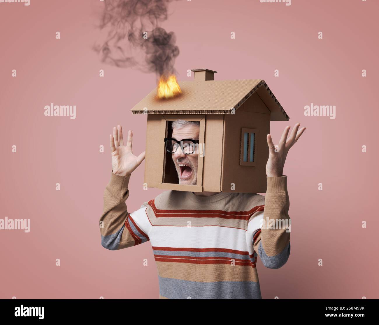 Shocked screaming homeowner with his head inside a burning cardboard ...