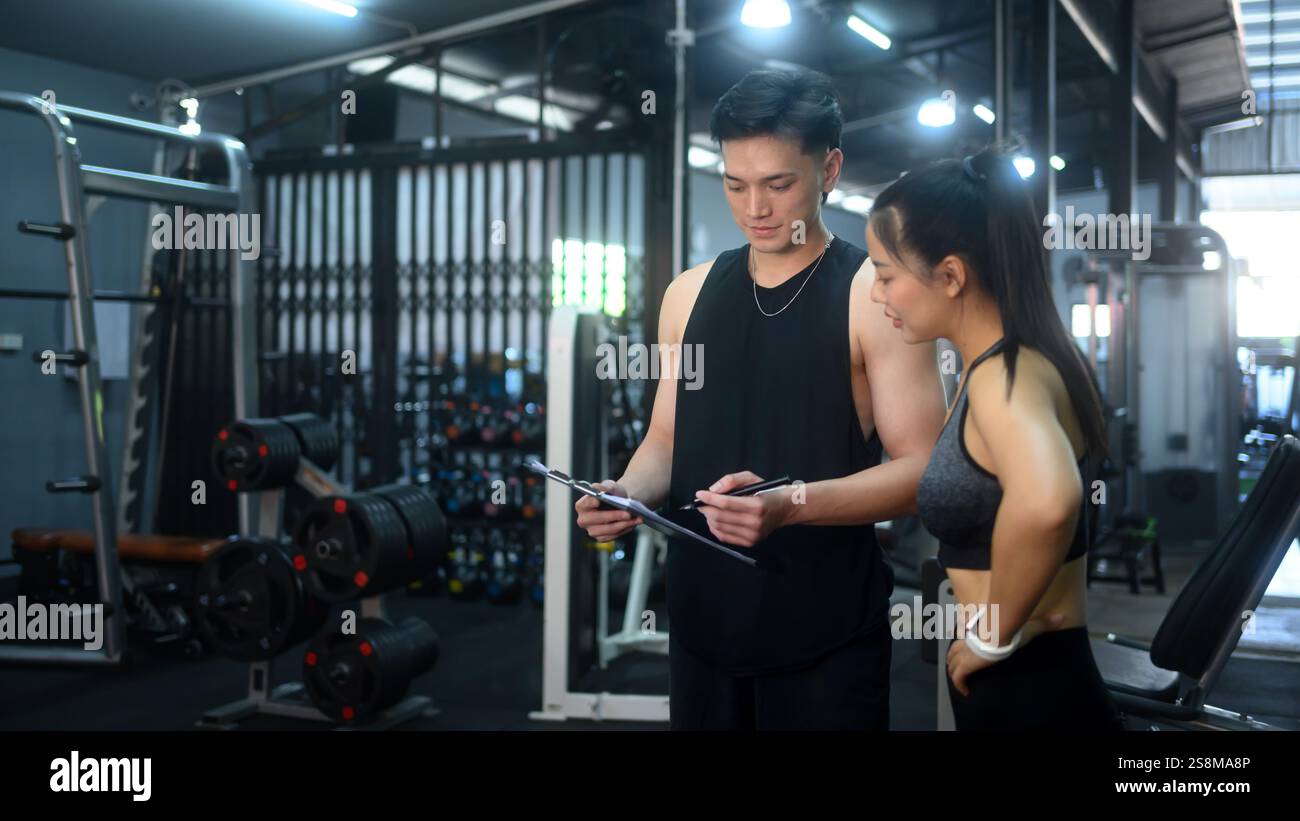 Male fitness Instructor and his client are discussing a workout plan in ...