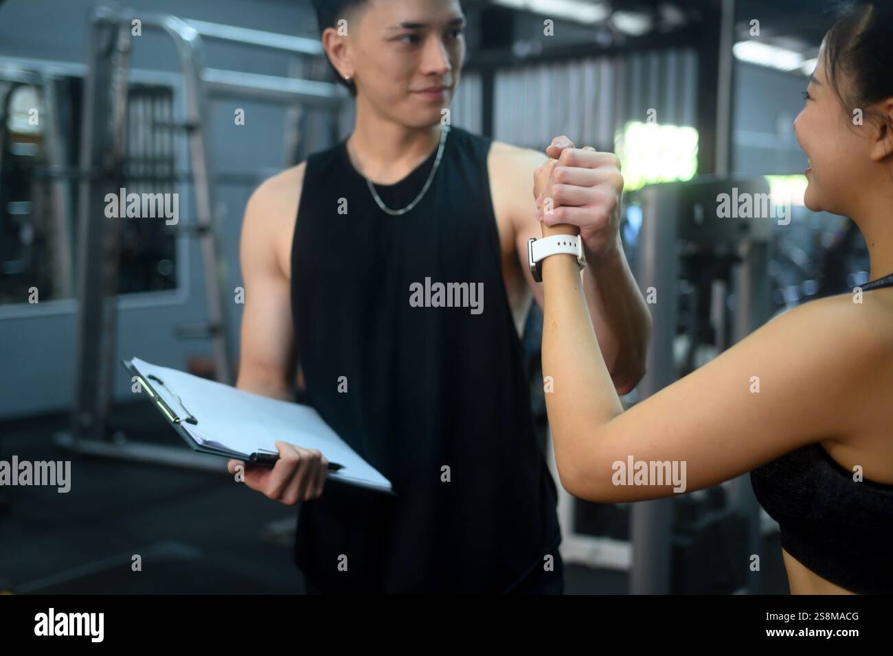 Male fitness Instructor and his client are discussing a workout plan in ...