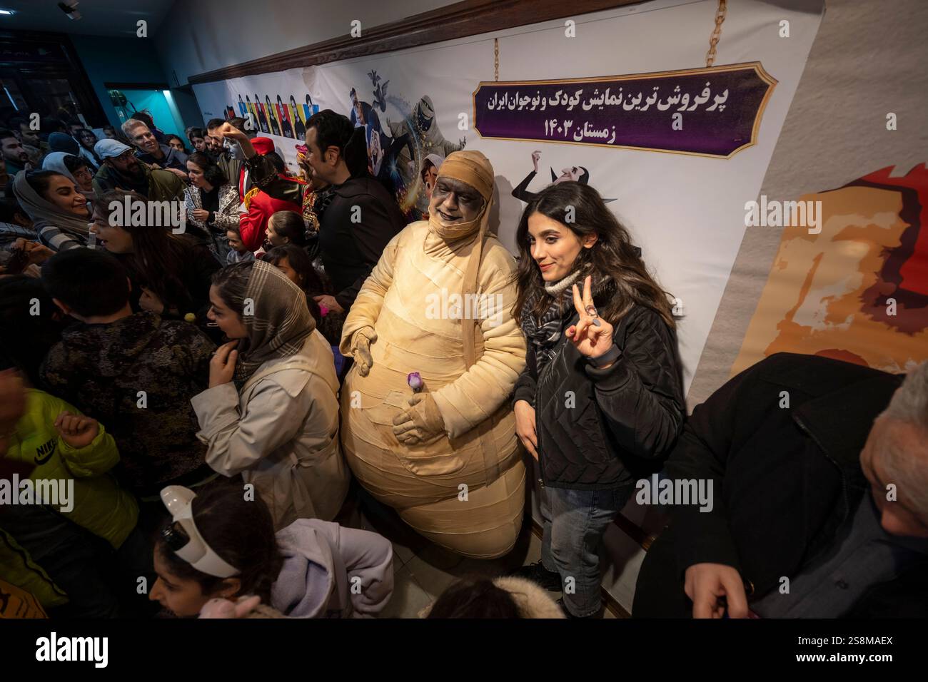 An Iranian woman flashes a victory sign as she poses for a photograph ...
