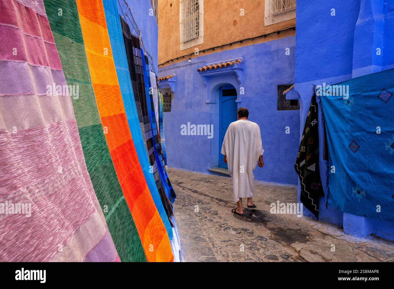 Colorful canvas and carpets on the walls of an alley inside the blue ...