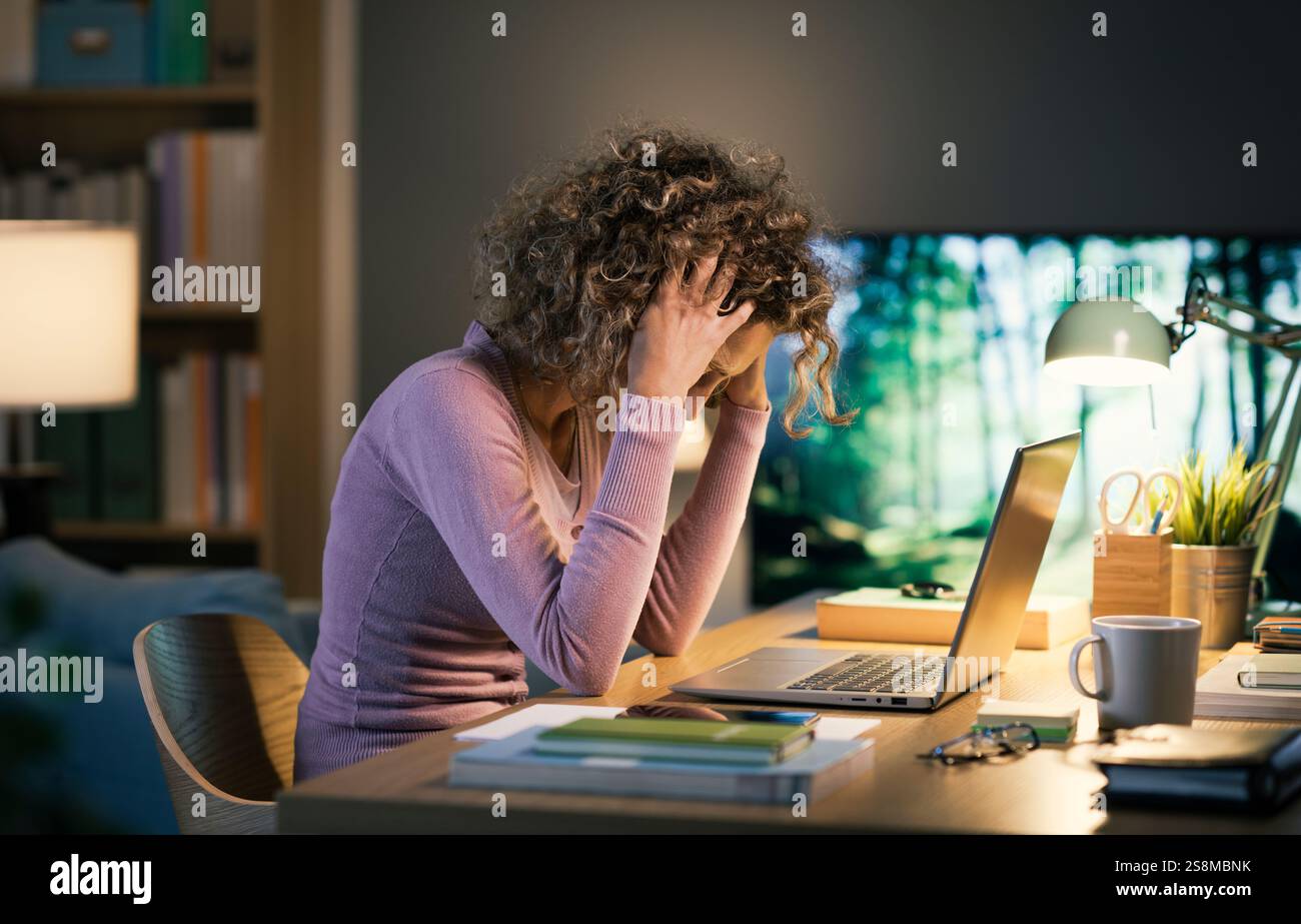 Stressed young woman working late in her home office, she had a bad ...
