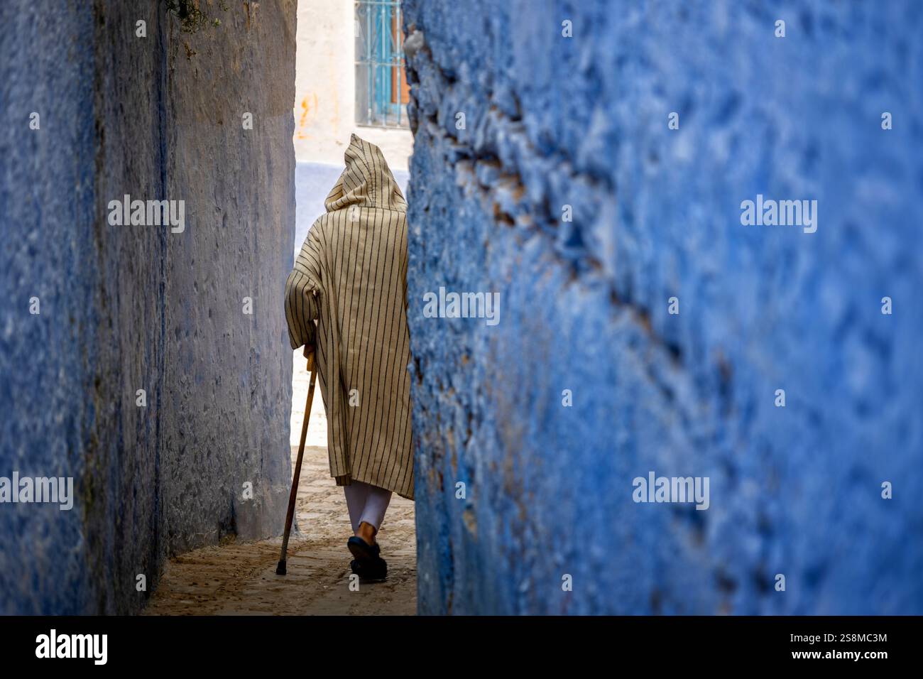 Elderly moroccan man wearing a traditional djellaba is walking on a ...