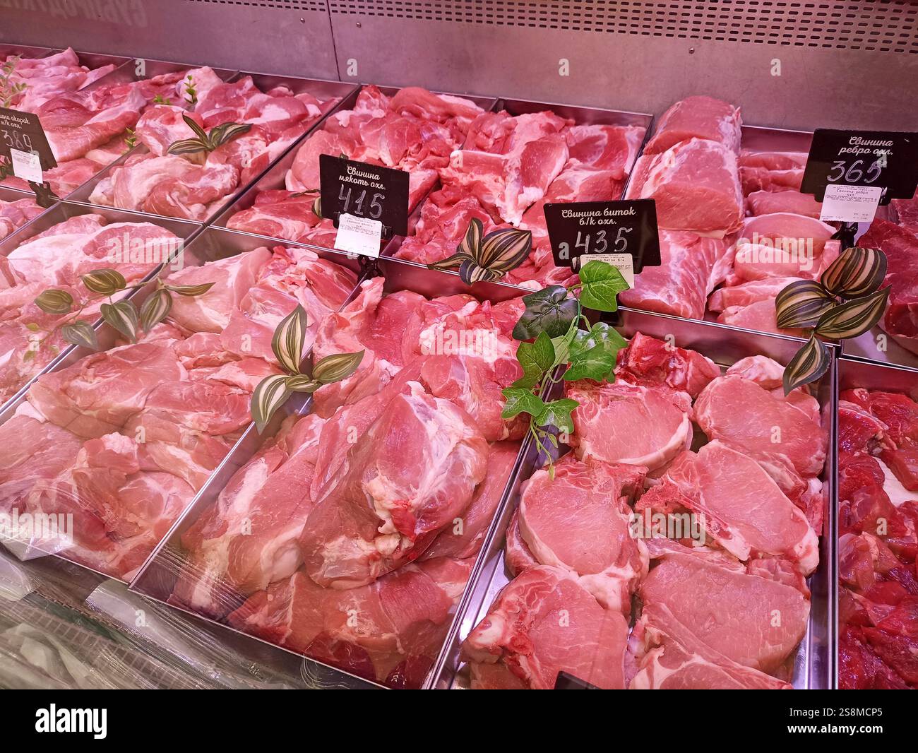 Variety of fresh raw pork cuts in grocery store display Stock Photo - Alamy