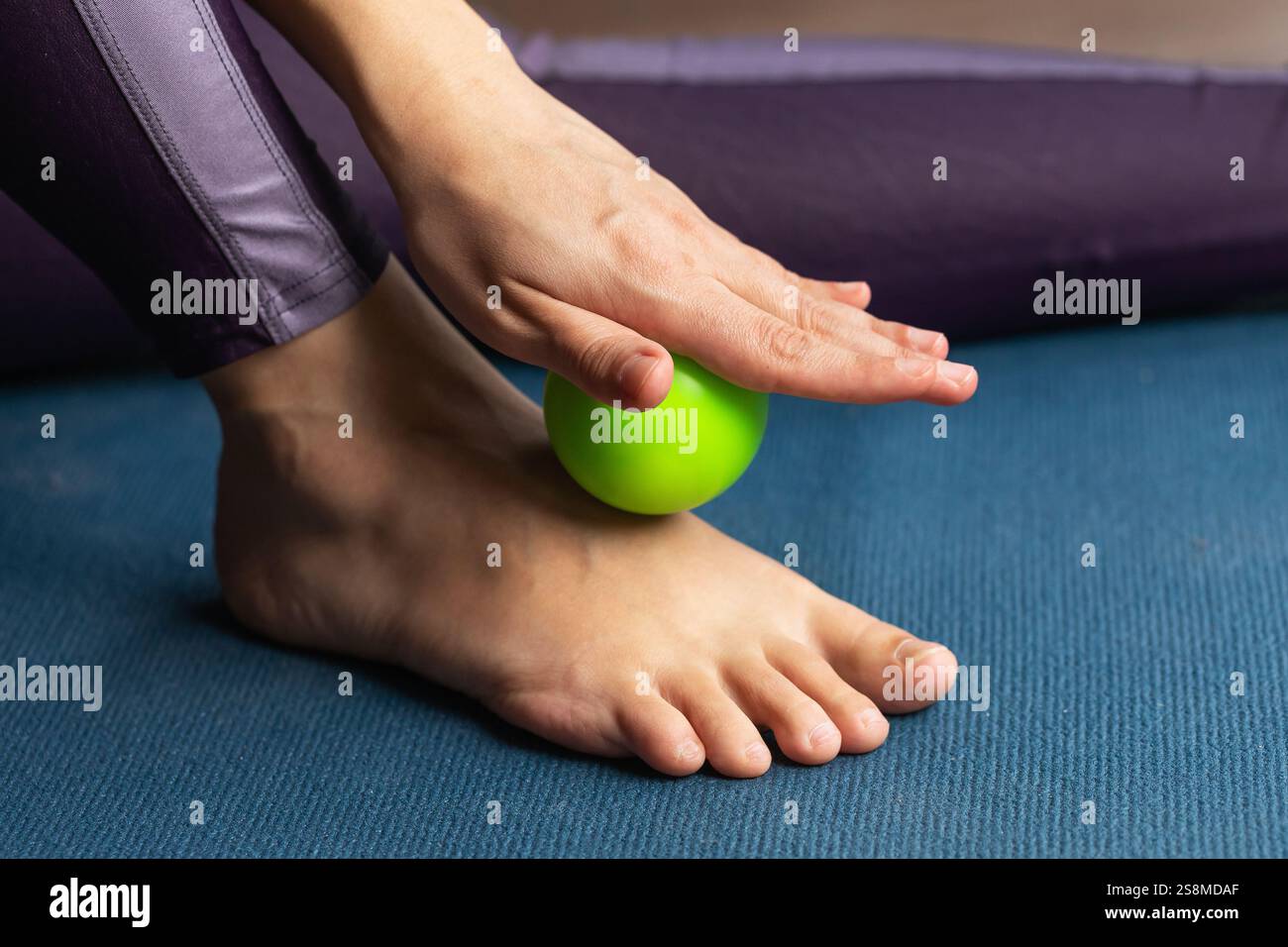 Man massaging foot muscles with small massage ball Stock Photo - Alamy