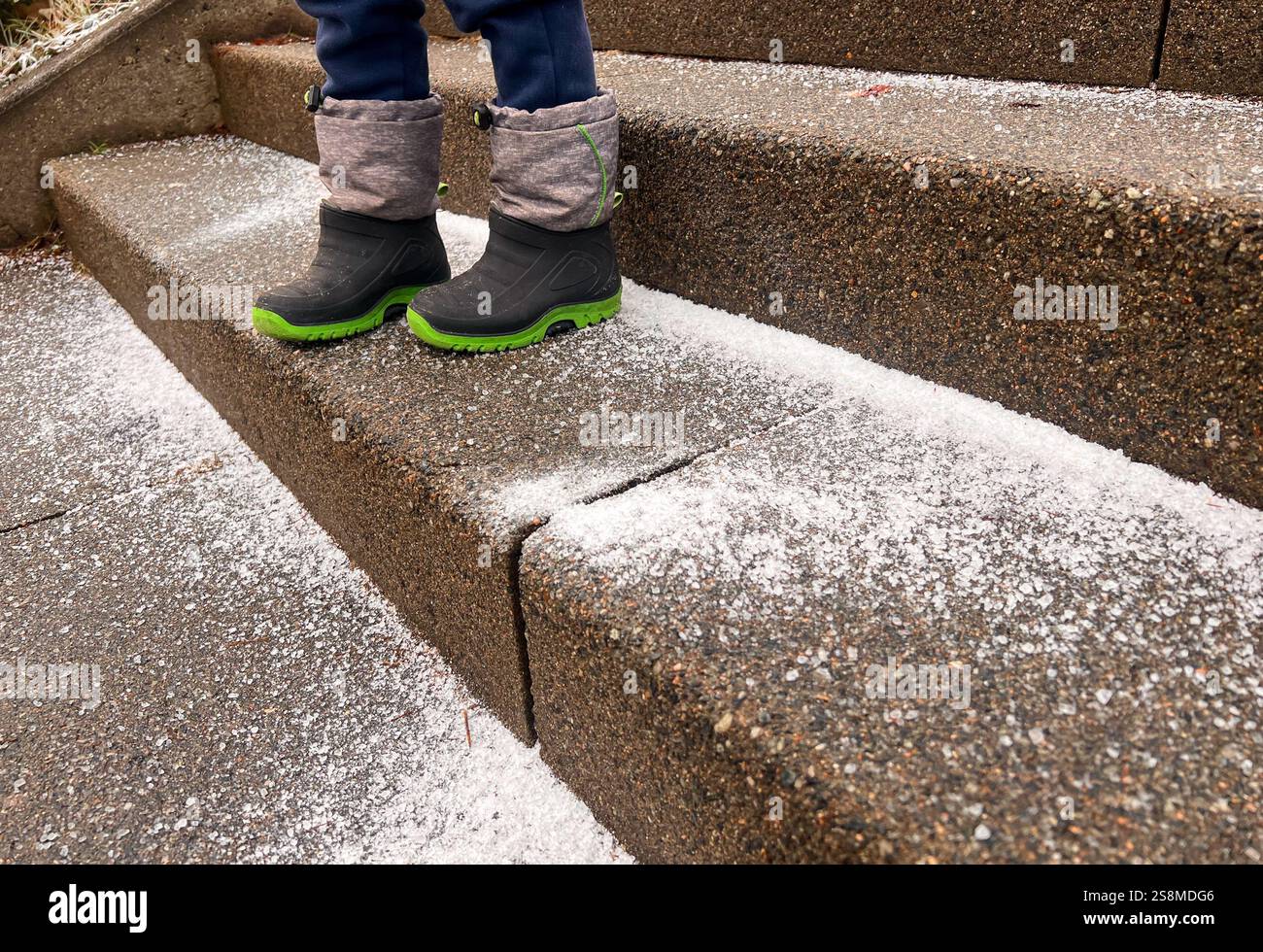 Close up of toddlers feet on stone steps outdoors covered with iced ...