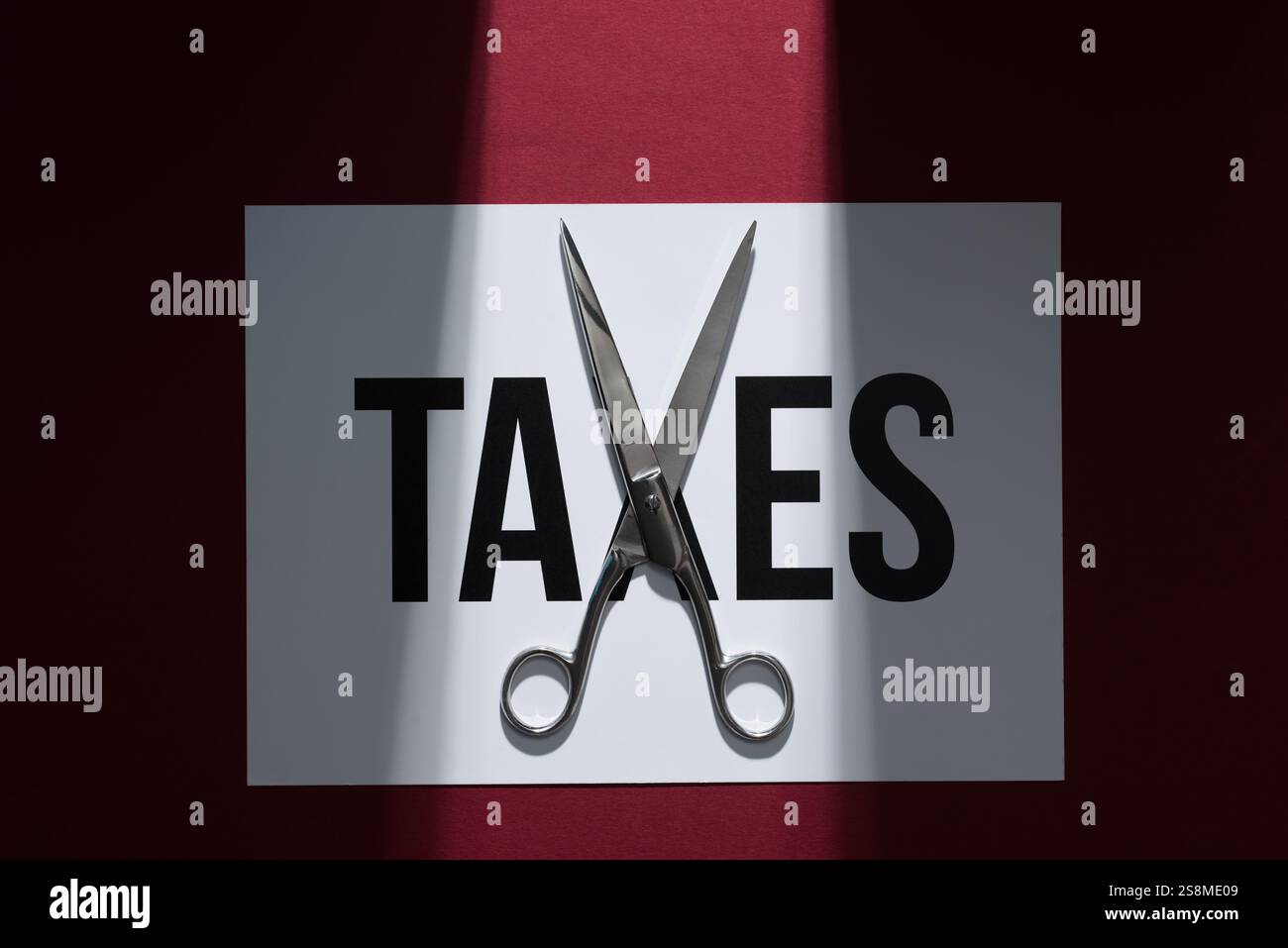TAXES text on a sheet and scissors: tax cut and tax reduction concept ...