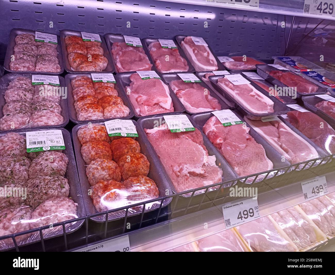 Variety of packaged meats on display in grocery store refrigerated ...
