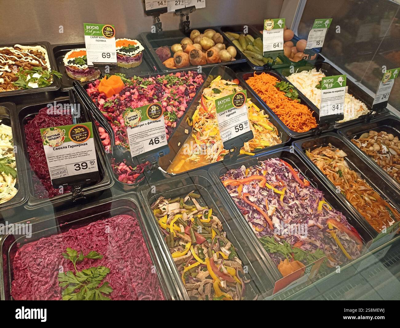 Diverse selection of fresh pre-made salads in grocery display case ...