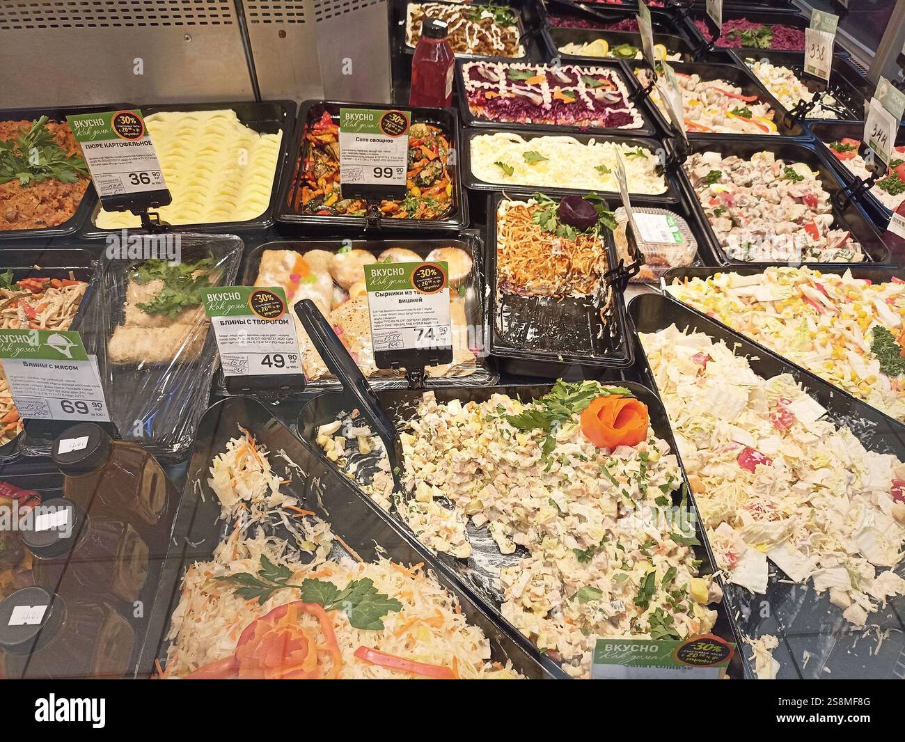Variety of prepared salads and dishes in a deli display at a grocery ...