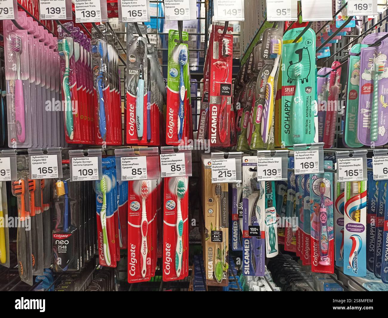 Variety of toothbrushes in a retail display with different brands and ...