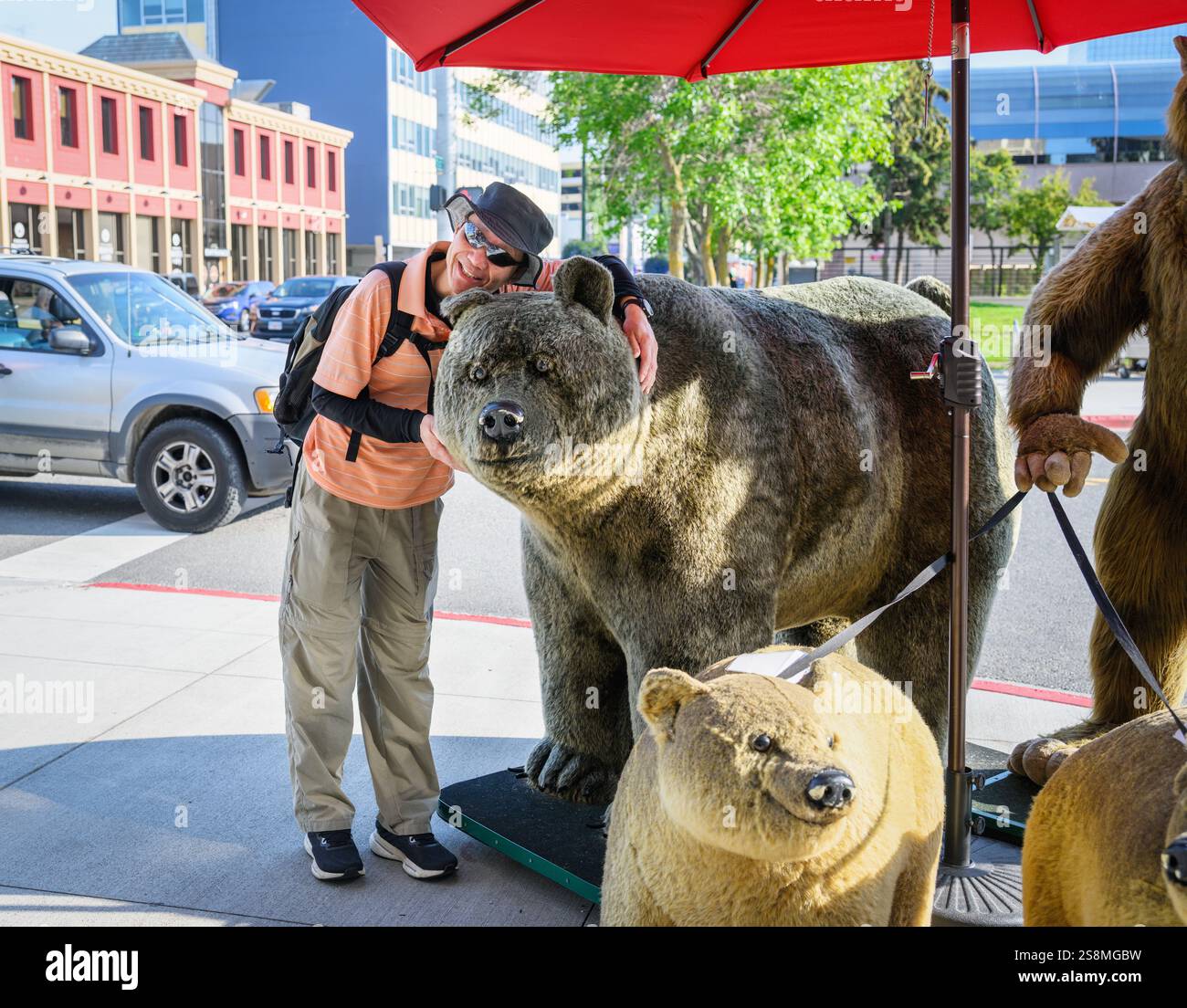 Tourist posing for photos with the giant stuffed grizzly bears in front ...