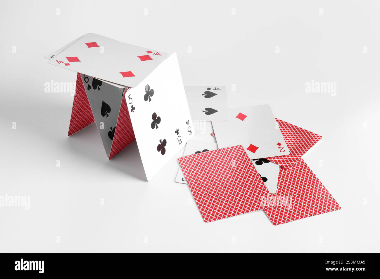 Collapsed house of playing cards on light background Stock Photo - Alamy