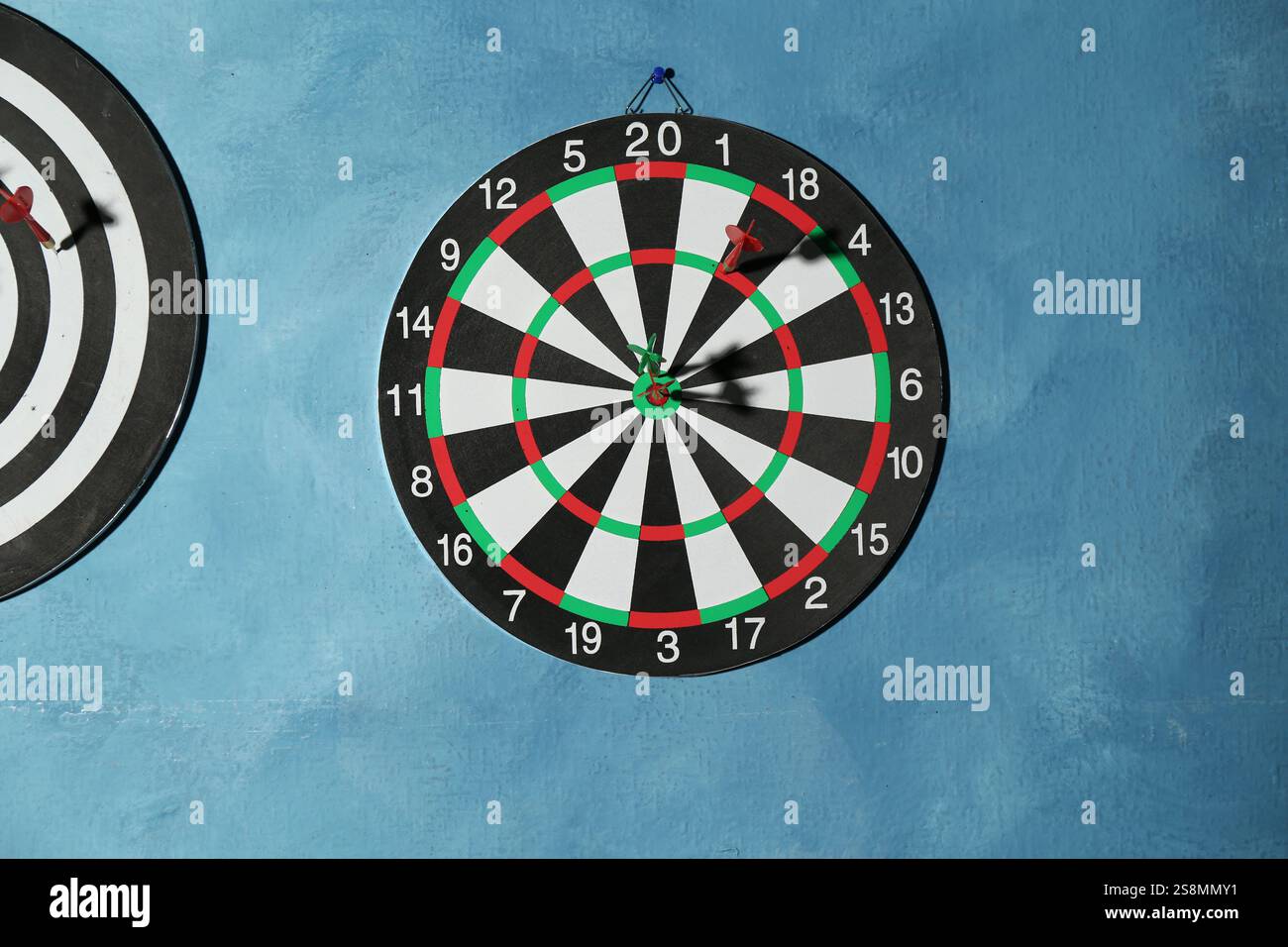 Dart boards with colorful arrows hanging on blue textured wall Stock ...