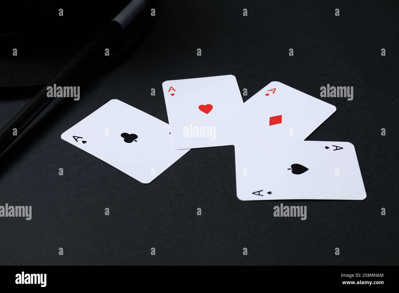 Playing cards, hat and magic wand on black background, closeup Stock ...