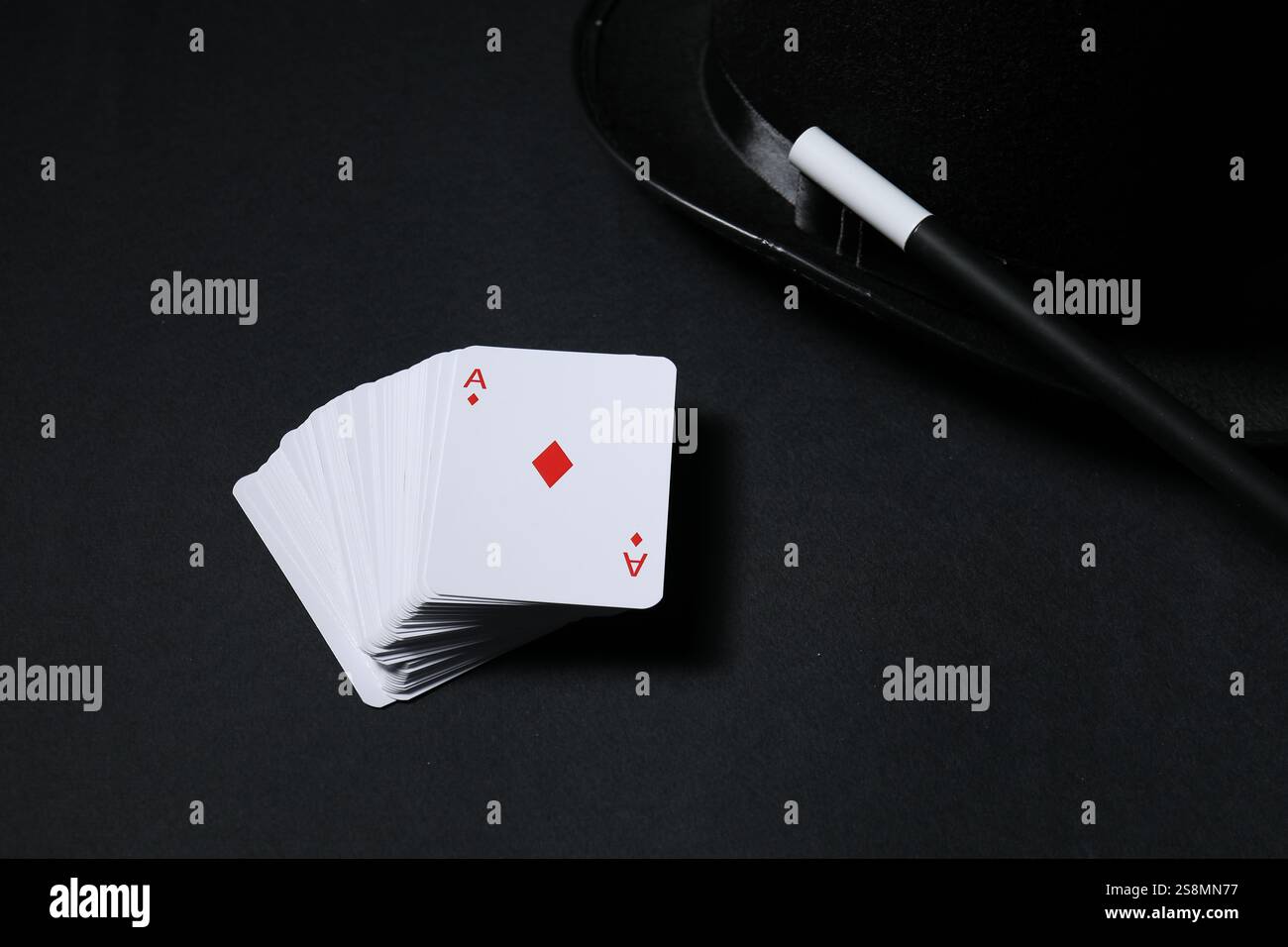 Playing cards, hat and magic wand on black background, closeup Stock ...