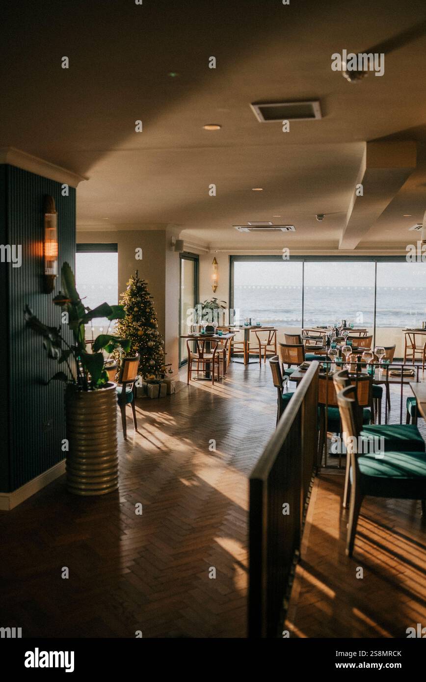 A restaurant with a Christmas tree in the middle of the room. The room ...