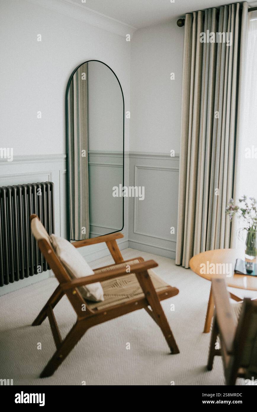 A living room with a large mirror above a radiator and two wooden ...