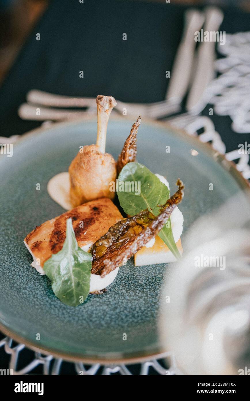 A plate of food with a green leafy vegetable and a piece of meat. The ...