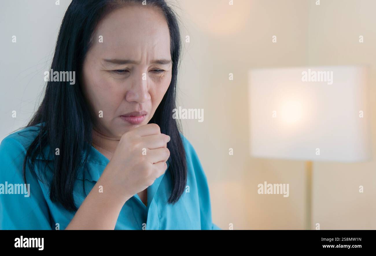 Cropped view of ill Asian female have a cough and sore throat at home ...