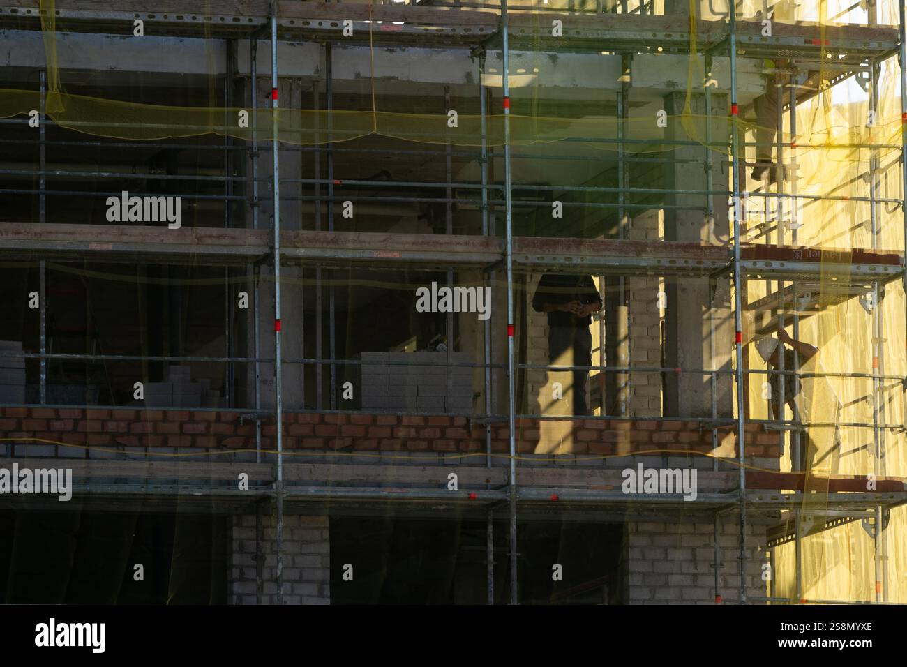 Malaga, Spain, 30 December 2024 builders working behind yellow ...