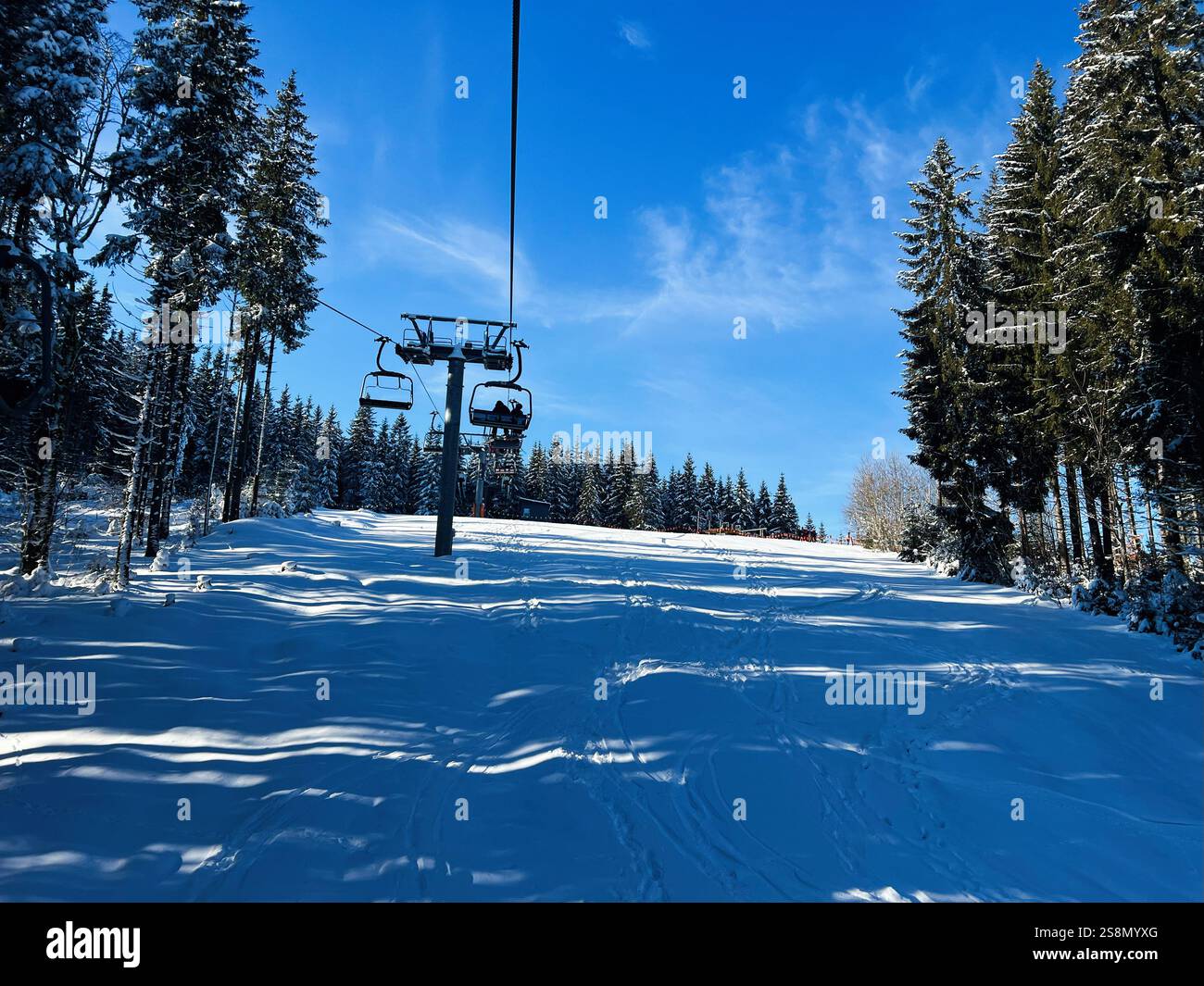 A beautiful ski slope surrounded by snow-covered evergreen trees and a ...