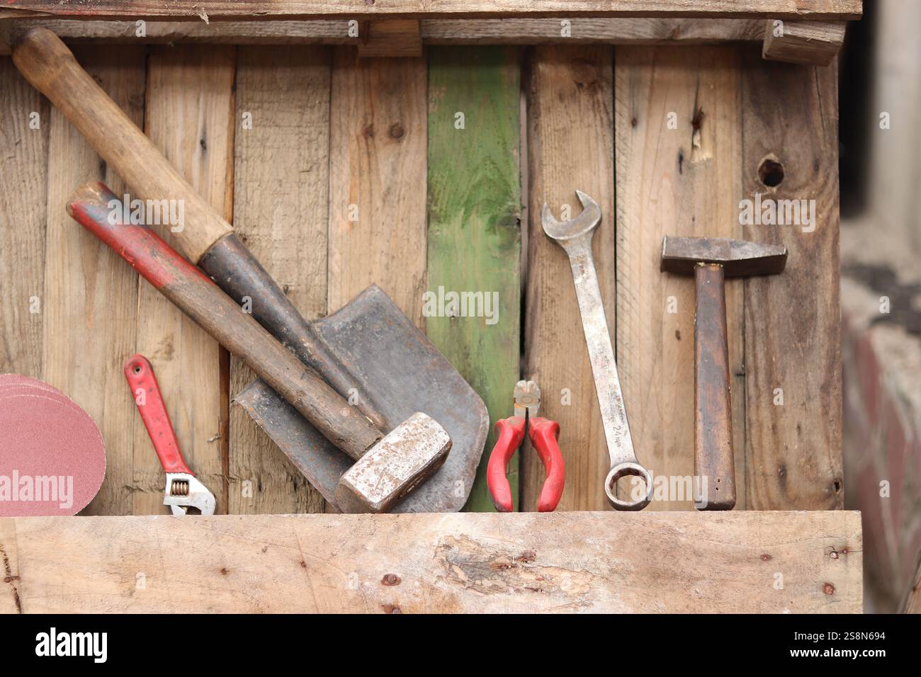Old hand tools on a background of wooden boards nailed together ...