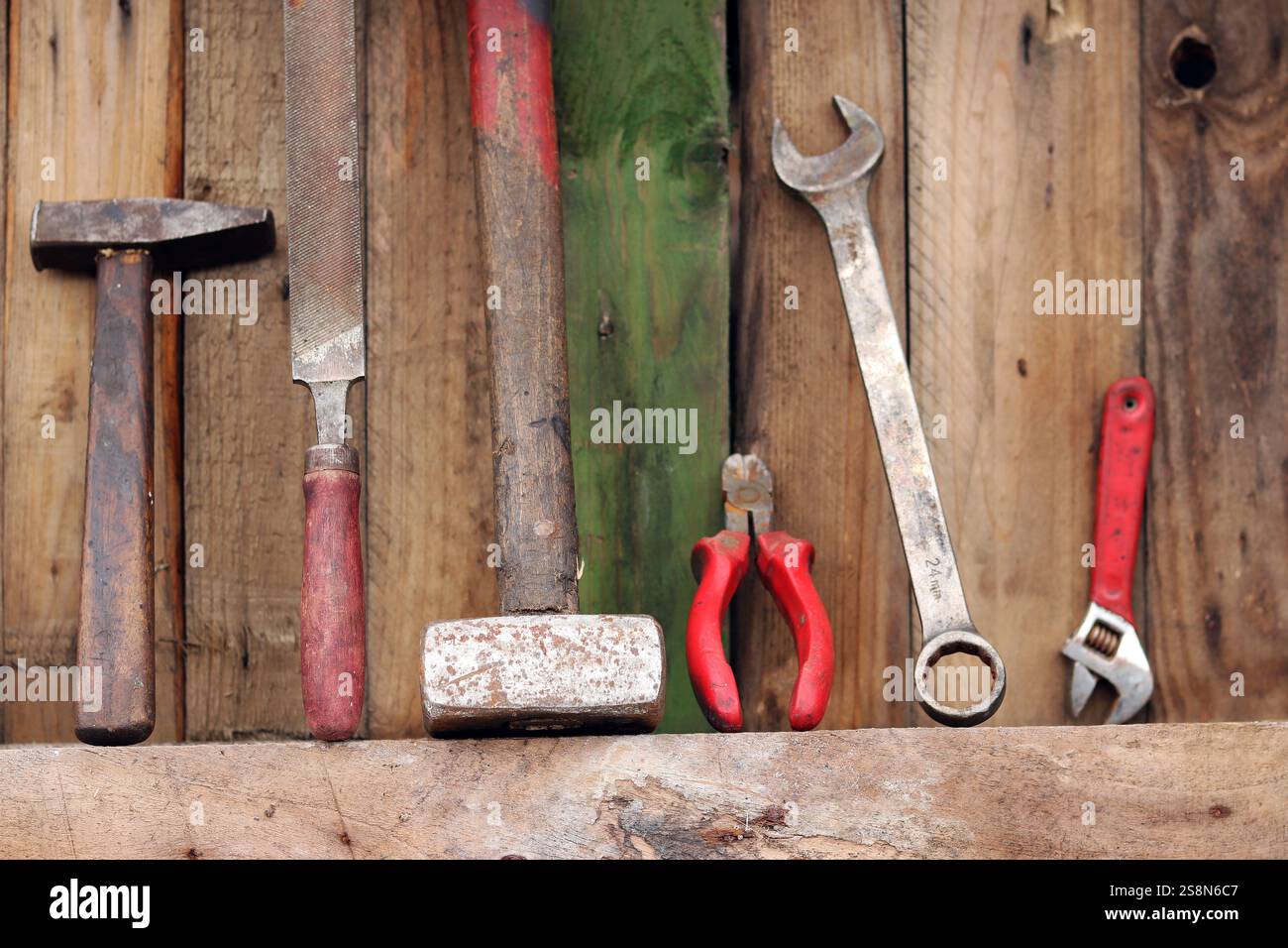 Old hand tools on a background of wooden boards nailed together ...