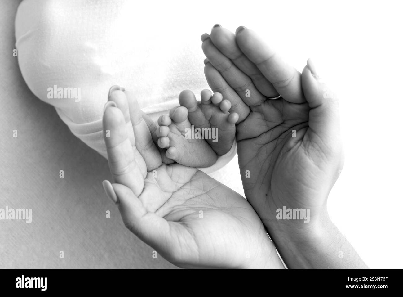 The palms of the parents. A father and mother hold the feet of a ...