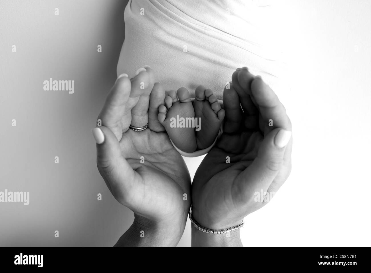 The palms of the parents. A father and mother hold the feet of a ...